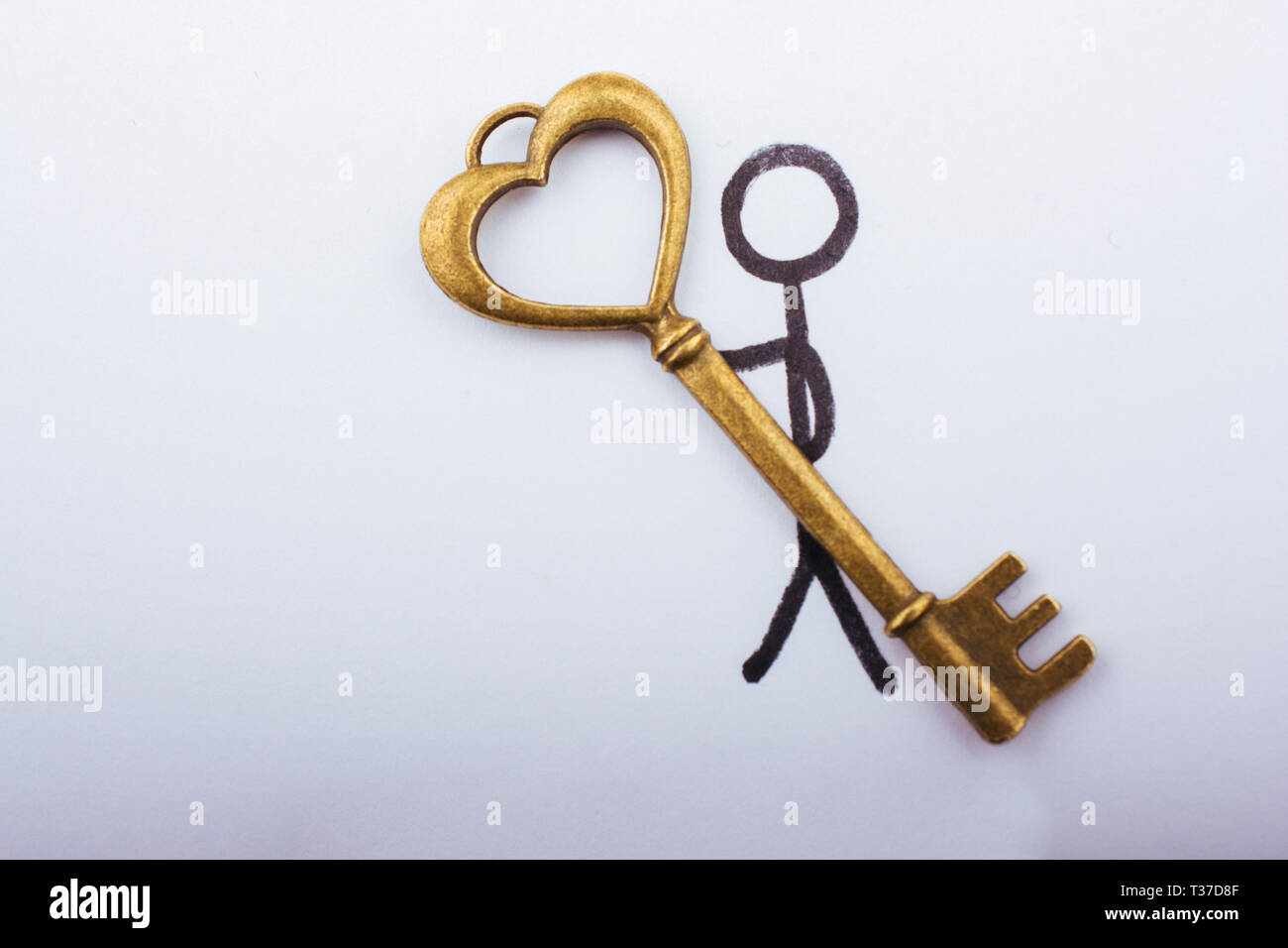 Man carrying a heart shaped key on white background Stock Photo - Alamy