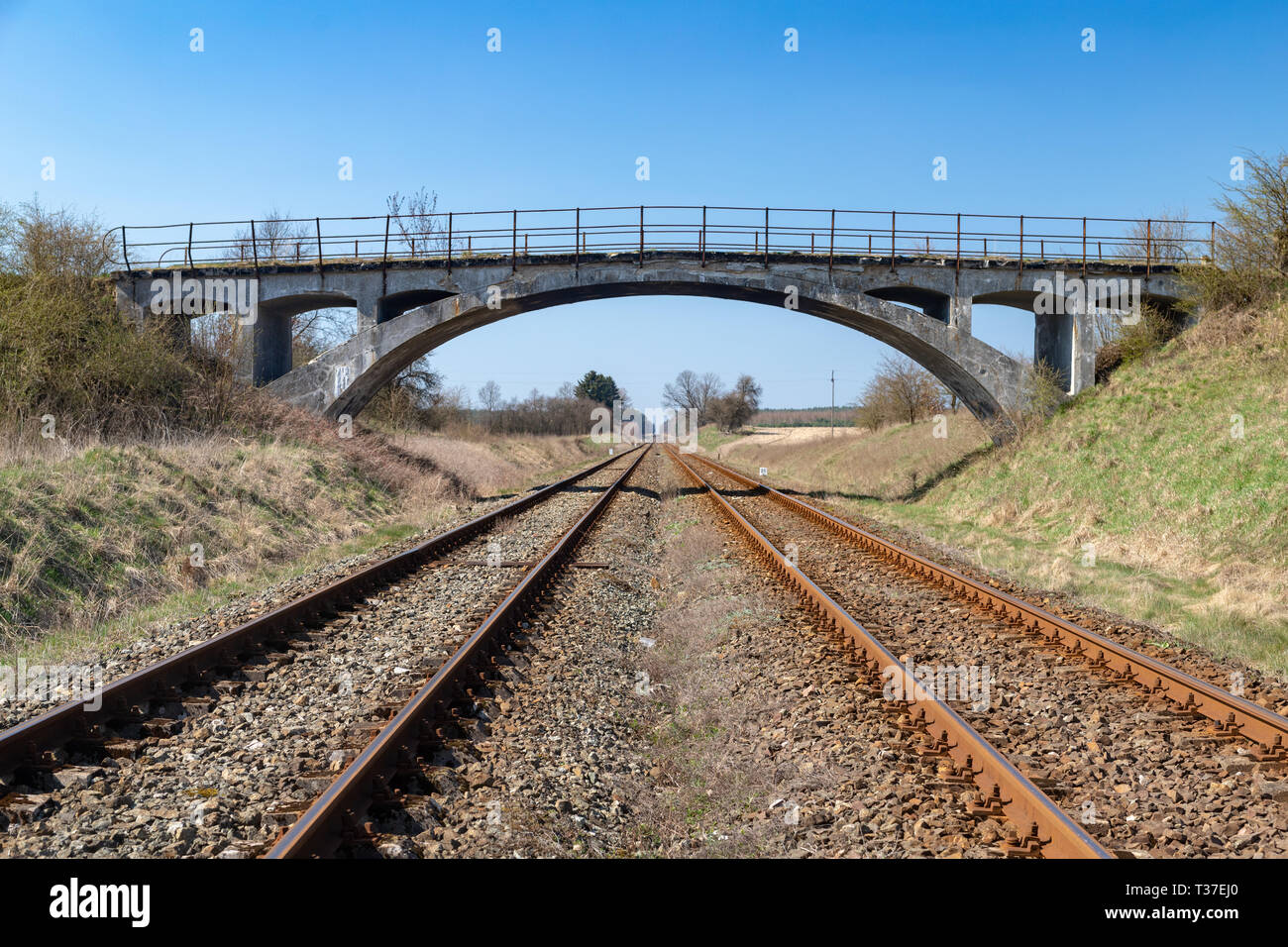 Old viaduct over the railway tracks. Concrete bridge over the railroad ...