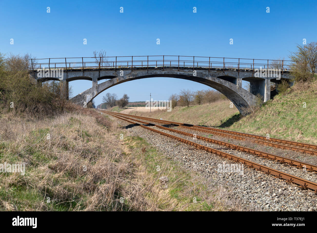 Old viaduct over the railway tracks. Concrete bridge over the railroad ...