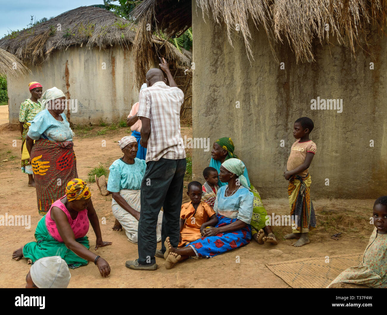 Malawian man addressing elderly women in Chiphazi village in the midst ...