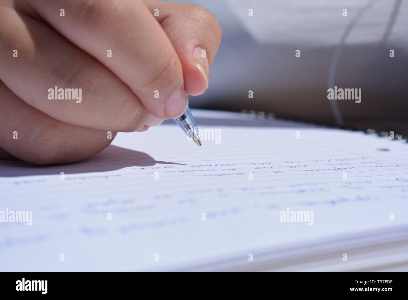 Woman writing in notebook, pen in hand Stock Photo - Alamy