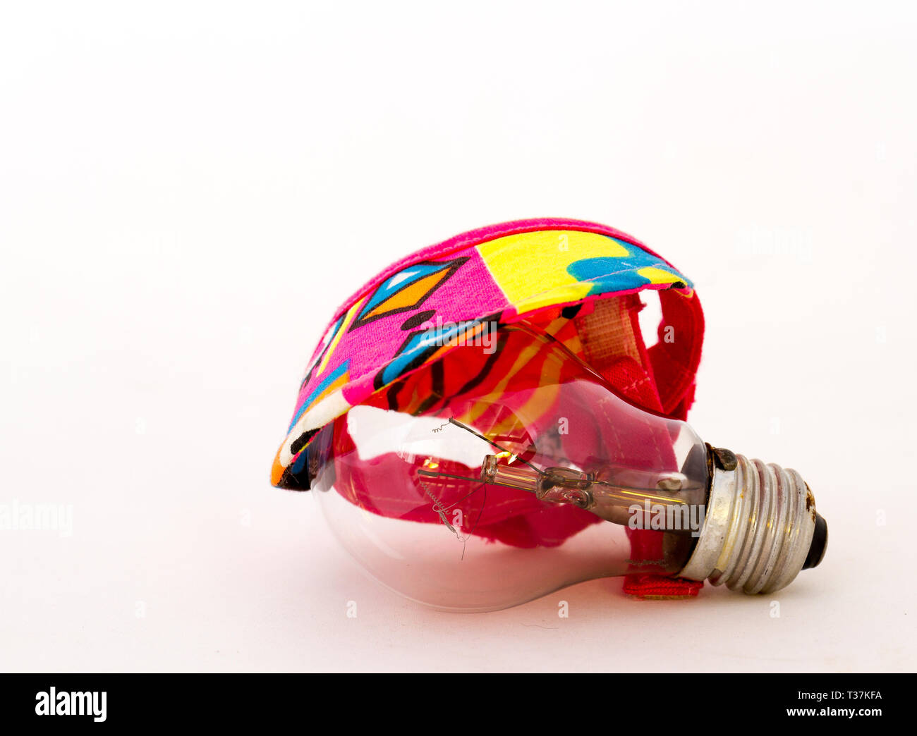 An electric light bulb under a colorful sun visor cap isolated on a ...