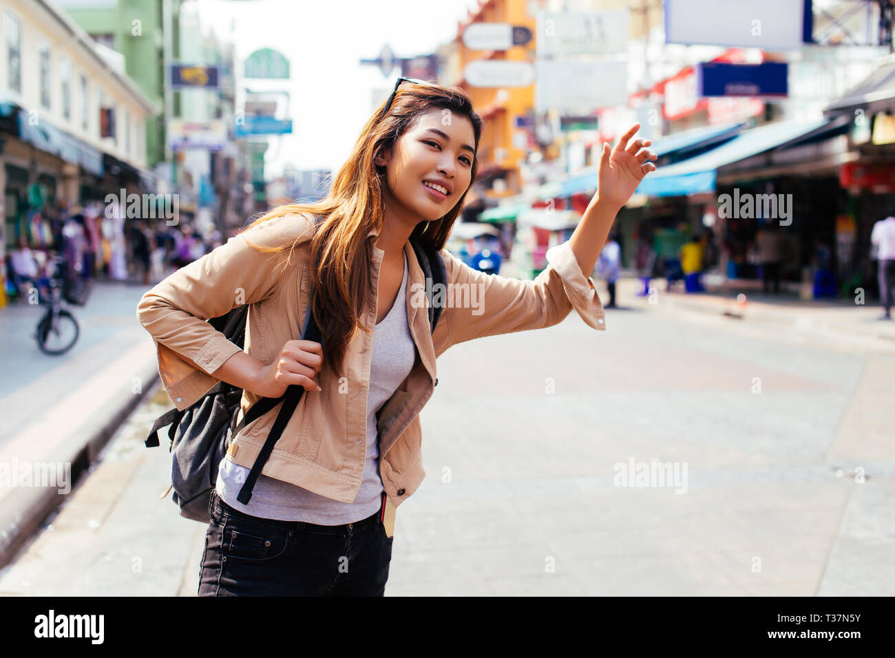 Young Asian female tourist calling a taxi in Thailand, Southeast Asia ...