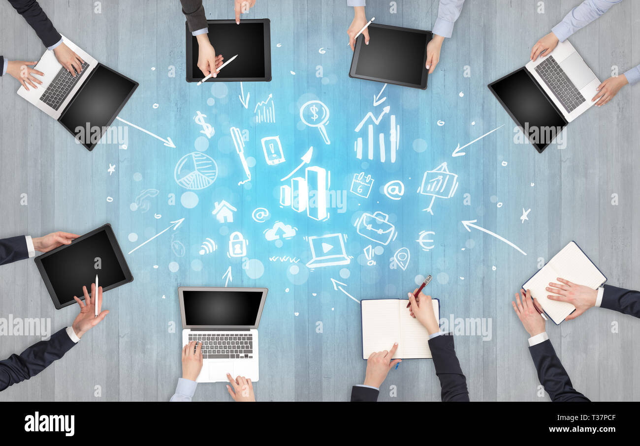 Group of people with devices in hands making reports together on laptop ...