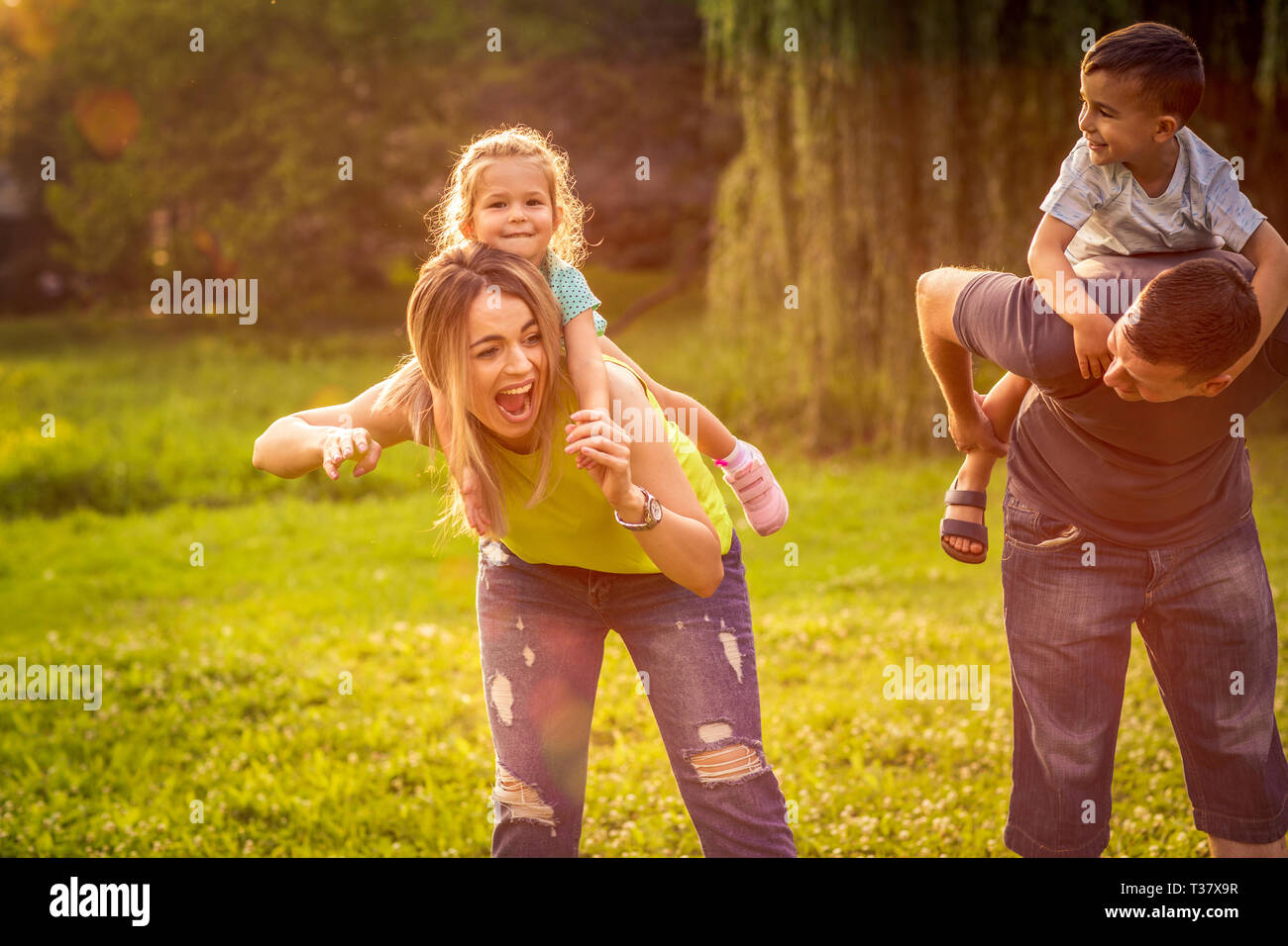 Funny time - Happy parents giving piggyback ride to children Stock ...
