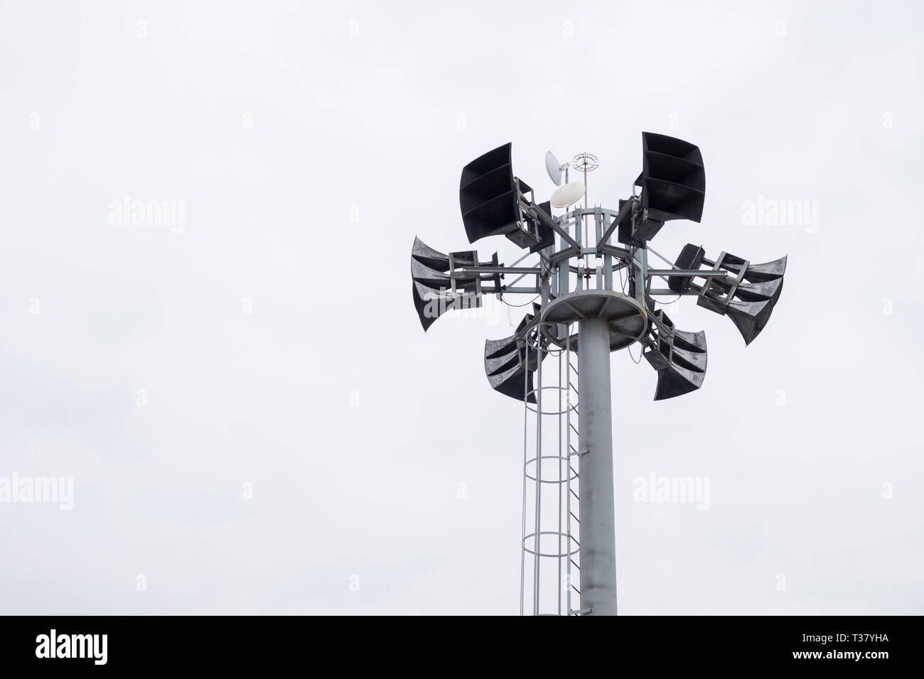 public address system, loudspeakers on mast outside against white sky ...