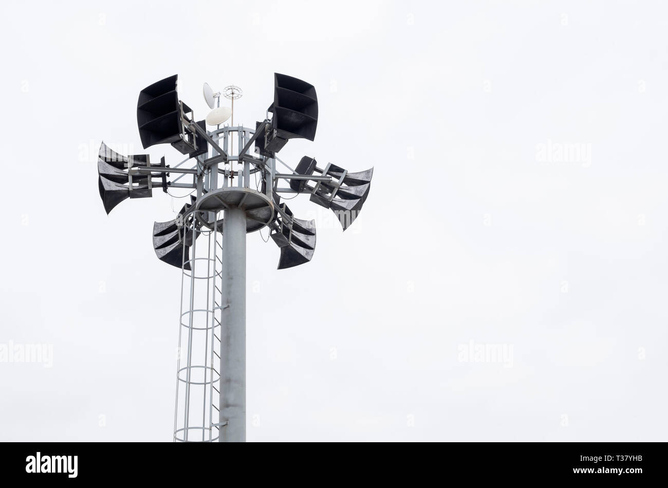 public address system, loudspeakers on mast outside against white sky ...