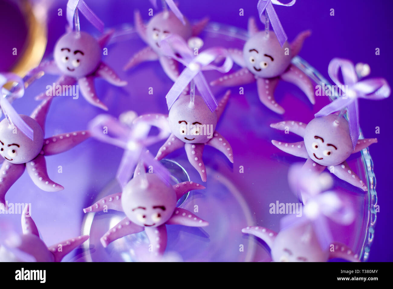 Purple cake pops funny octopuses shared on the glass round plate and ...