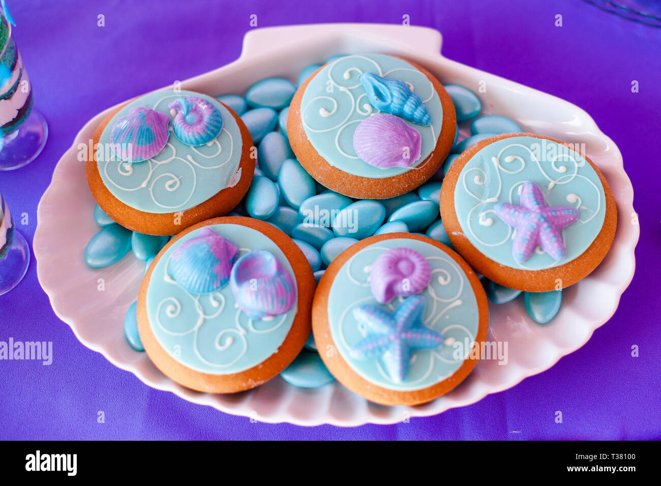 White shell plate full of chocolate candies with blue icing, cookies ...