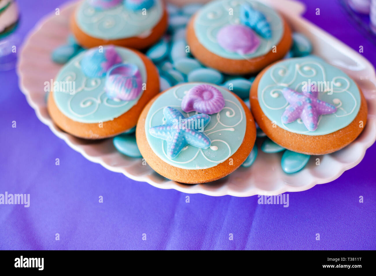 White shell plate full of chocolate candies with blue icing, cookies ...