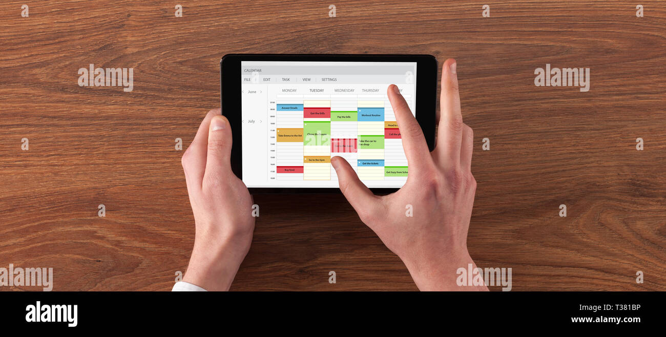 Hand holding tablet with timetable and calendar concept Stock Photo - Alamy