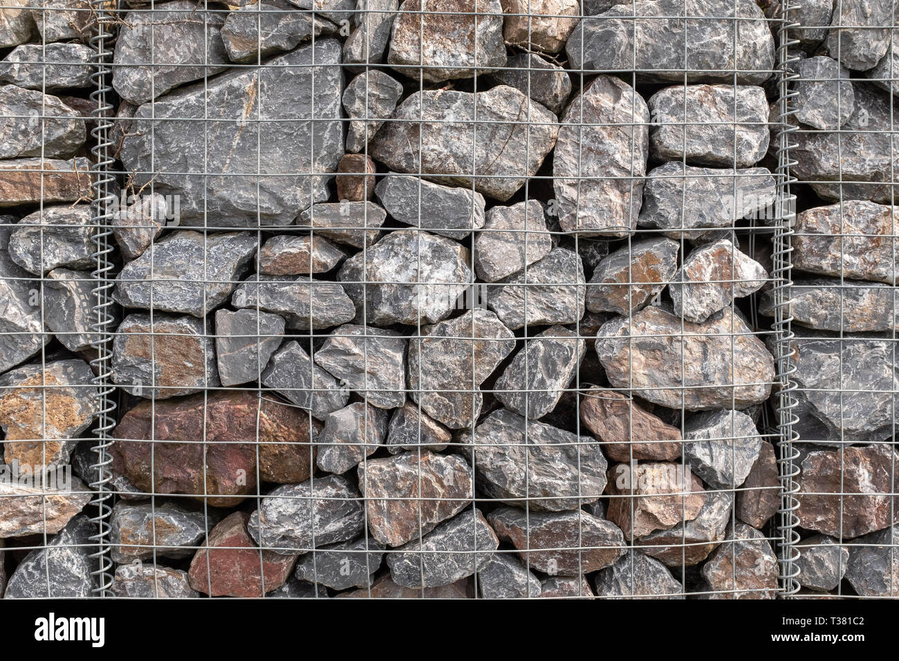 A close up of a pile of granite rocks in a metal cage used for flood ...