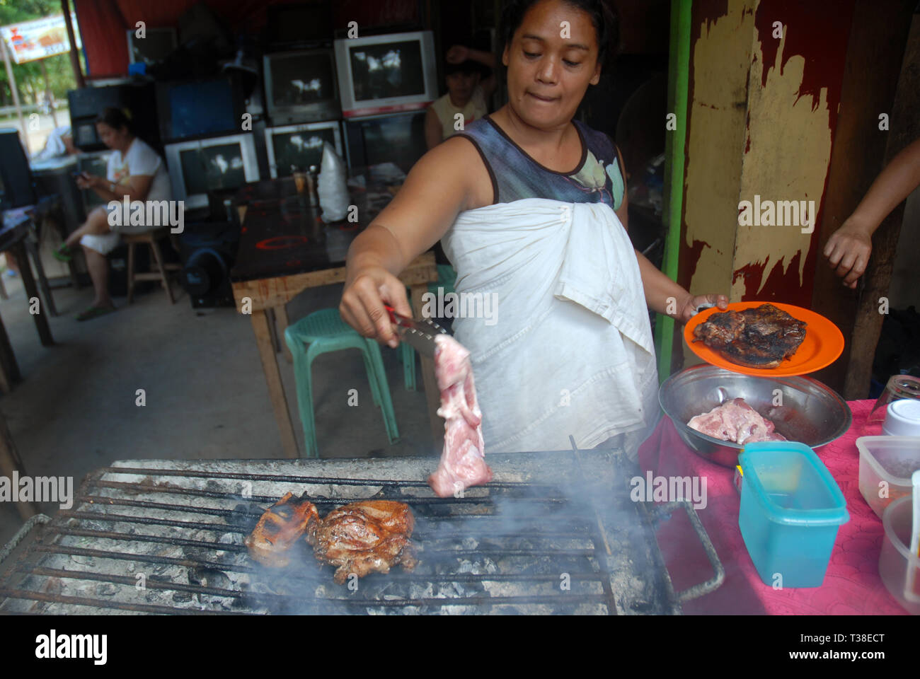 Lady cooking meat to sell at food stall, Samal, Philippines Stock Photo ...
