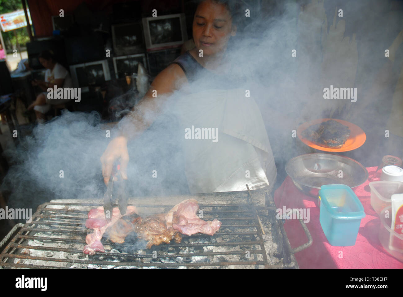 Lady cooking meat to sell at food stall, Samal, Philippines Stock Photo ...