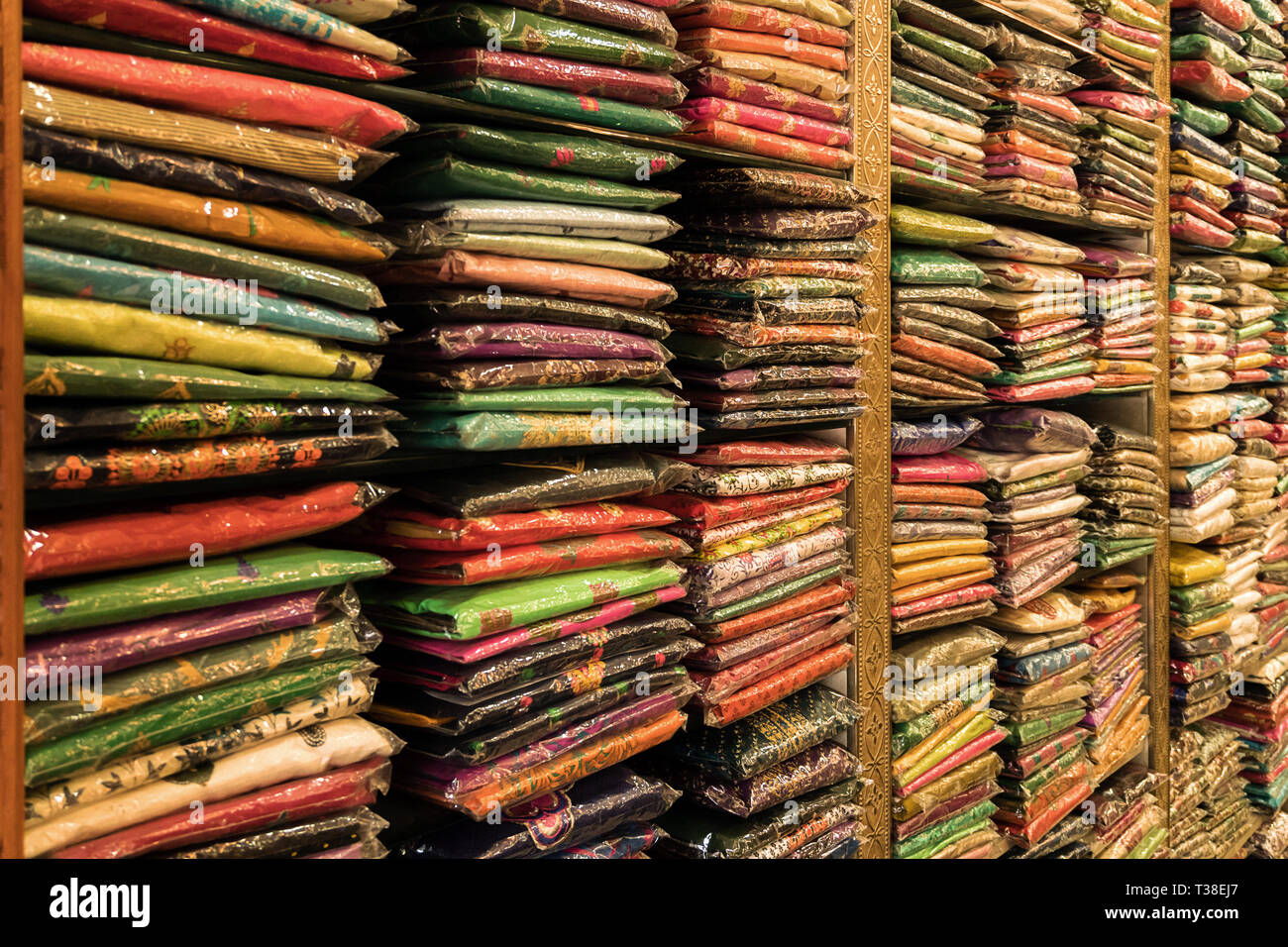 Colorful folded fabric sitting on a shelf in Little India. Shelf with ...