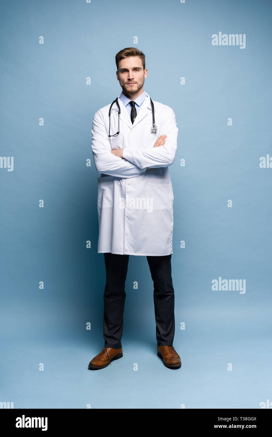 Full length young medical doctor on blue background Stock Photo - Alamy