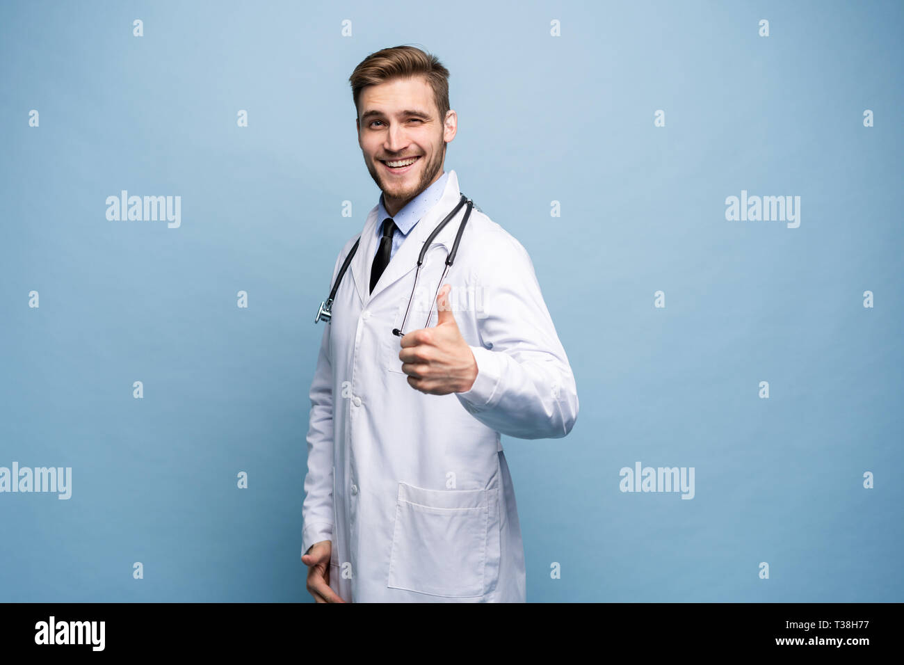 Portrait of a friendly doctor smiling giving thumbs up Stock Photo - Alamy