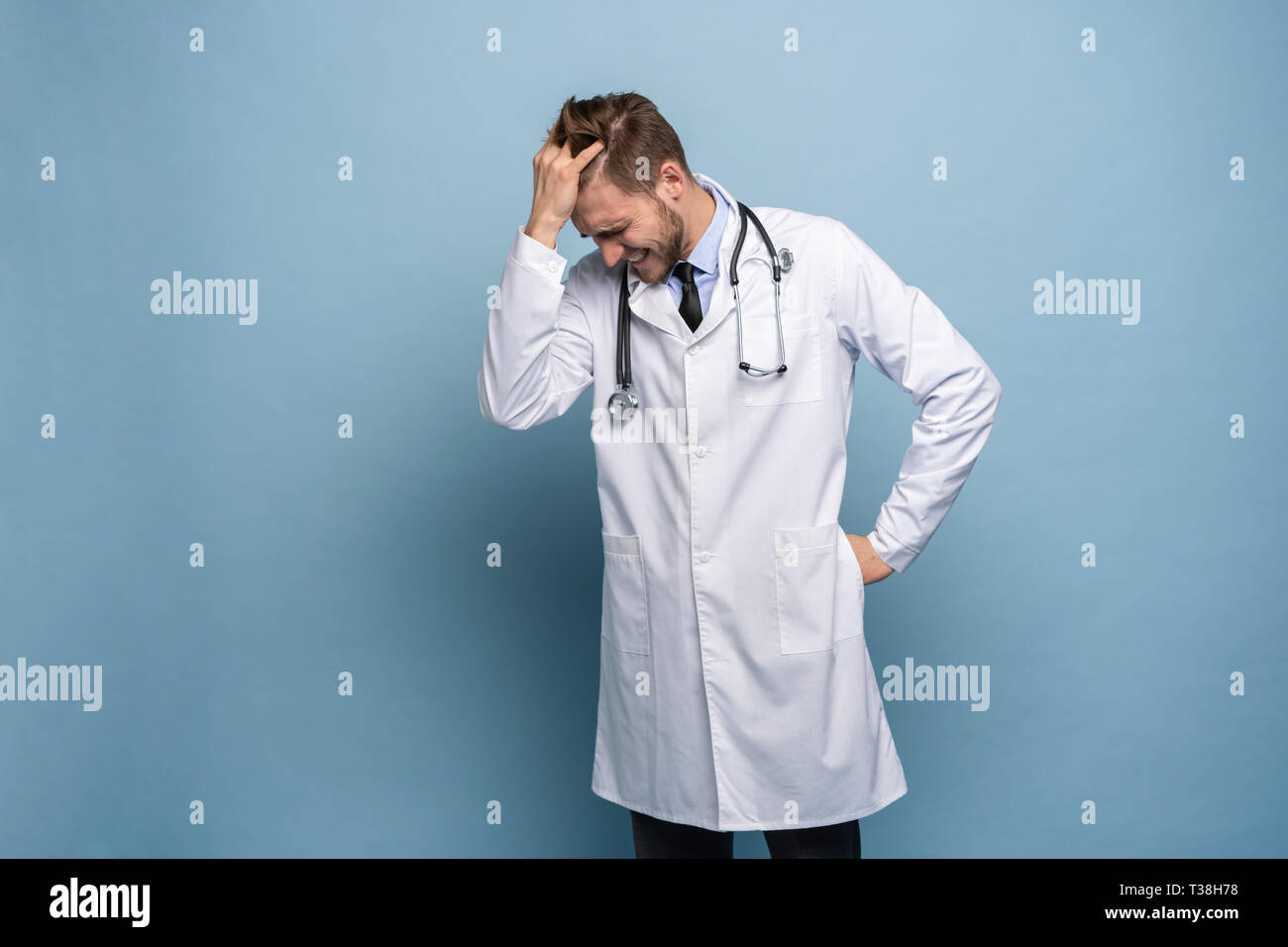 Doctor young man, medical professional terrified and nervous expressing ...
