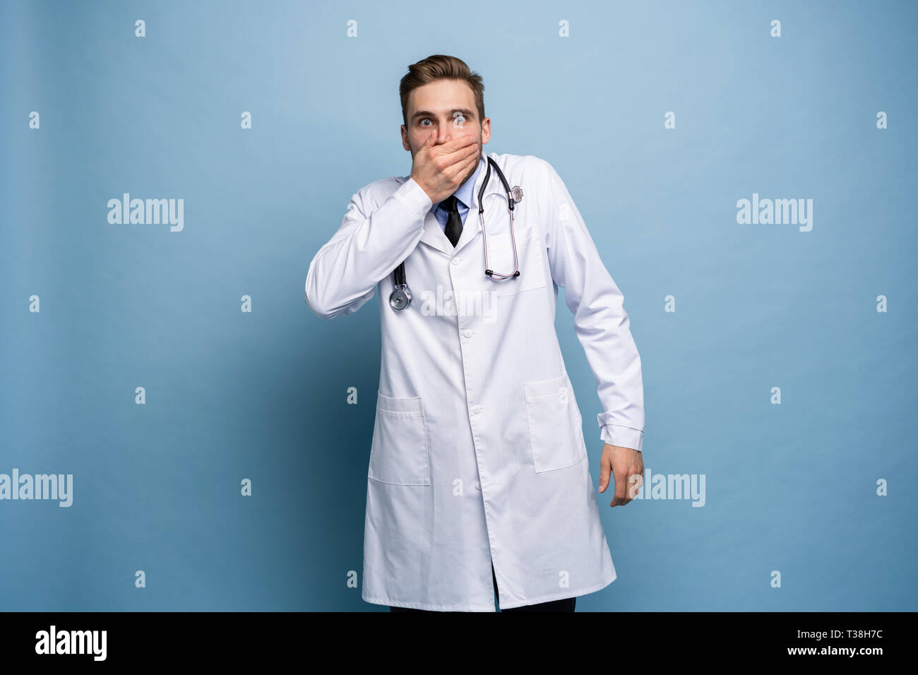 Doctor young man, medical professional terrified and nervous expressing ...