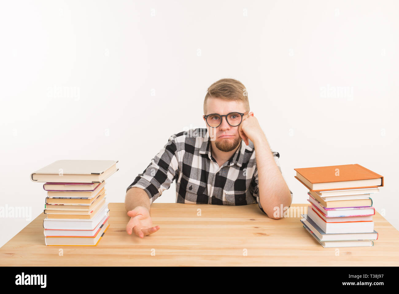 People, knowledge and education concept - Tired male student sitting at ...