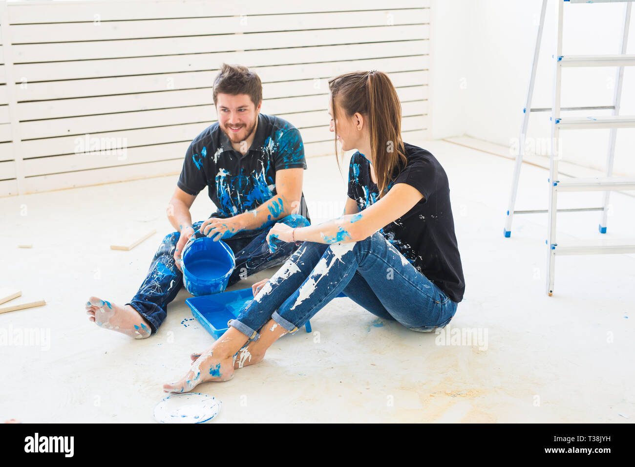 Repair, color, people concept- couple going to paint the wall, they are ...