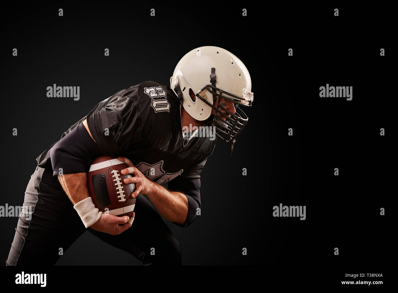 Portrait of american football player with helmet, close up, on black ...