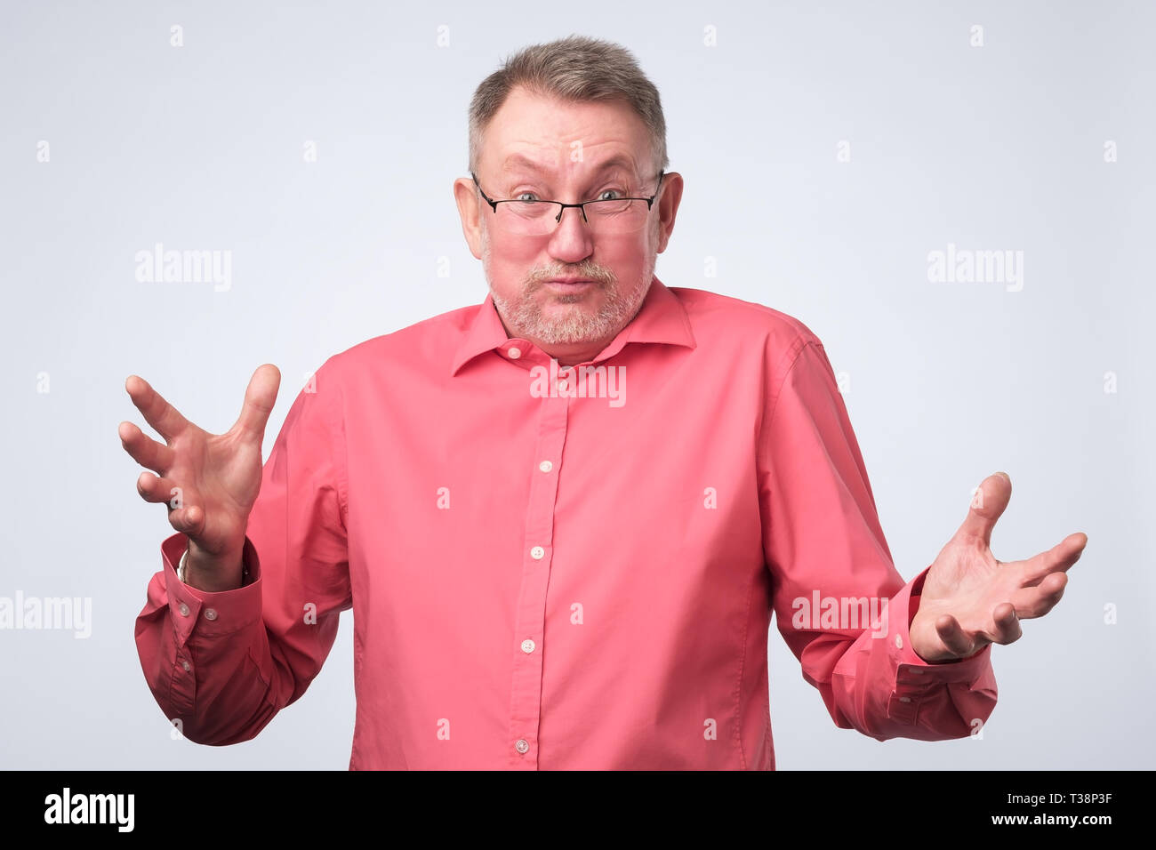 Happy senior guy in red shirt laughing at funny joke at studio ...