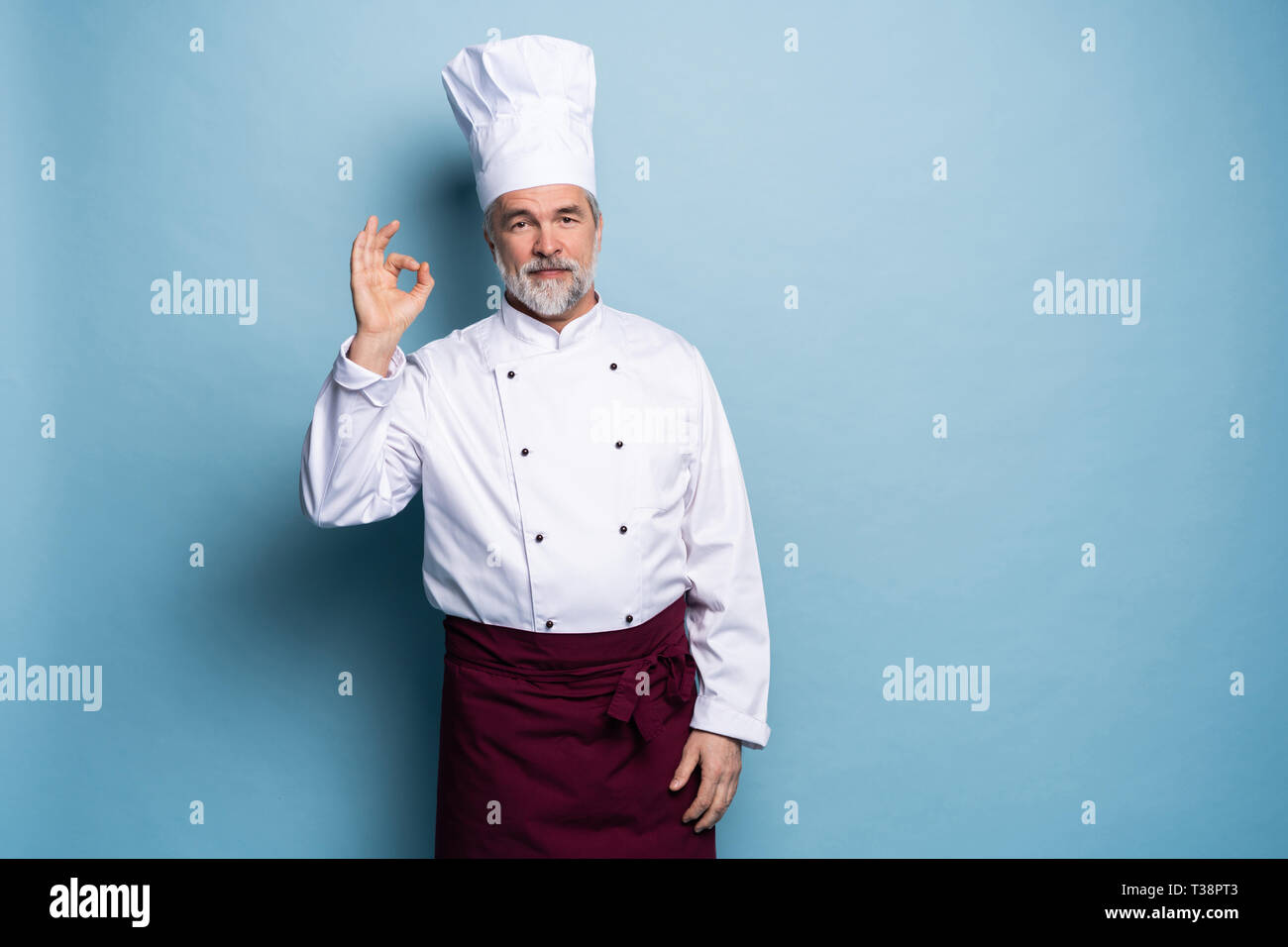 Mature professional happy man chef showing tasty ok sign isolated on ...