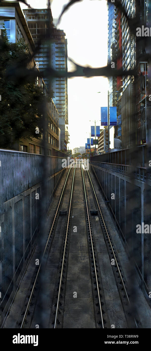 Mass transit rail tracks diving under ground Stock Photo - Alamy