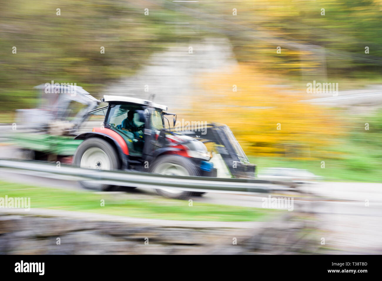 Tractor in full speed motion passing by Stock Photo - Alamy