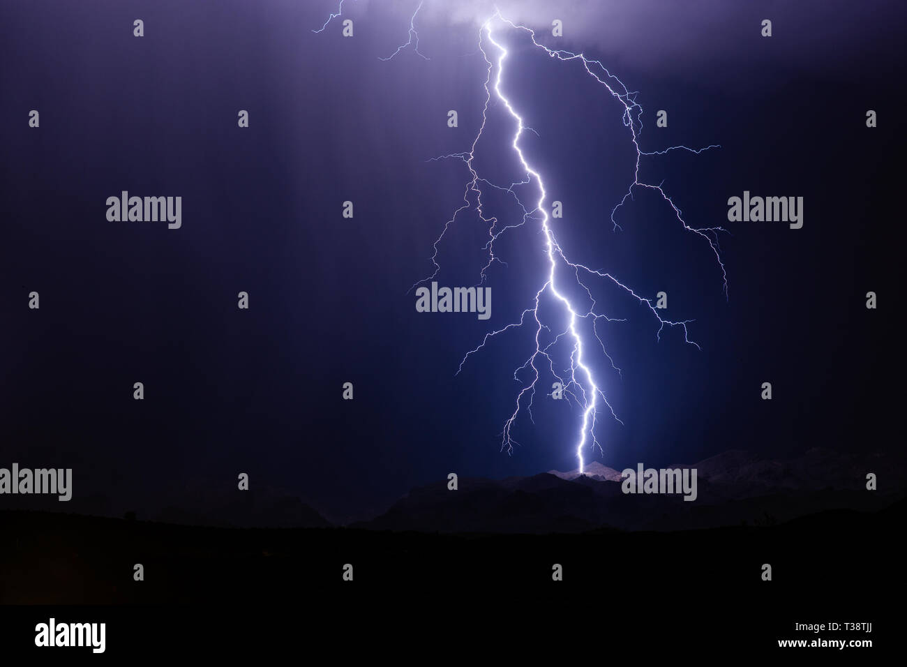 Lightning bolt strike hitting a mountain in a monsoon storm near ...