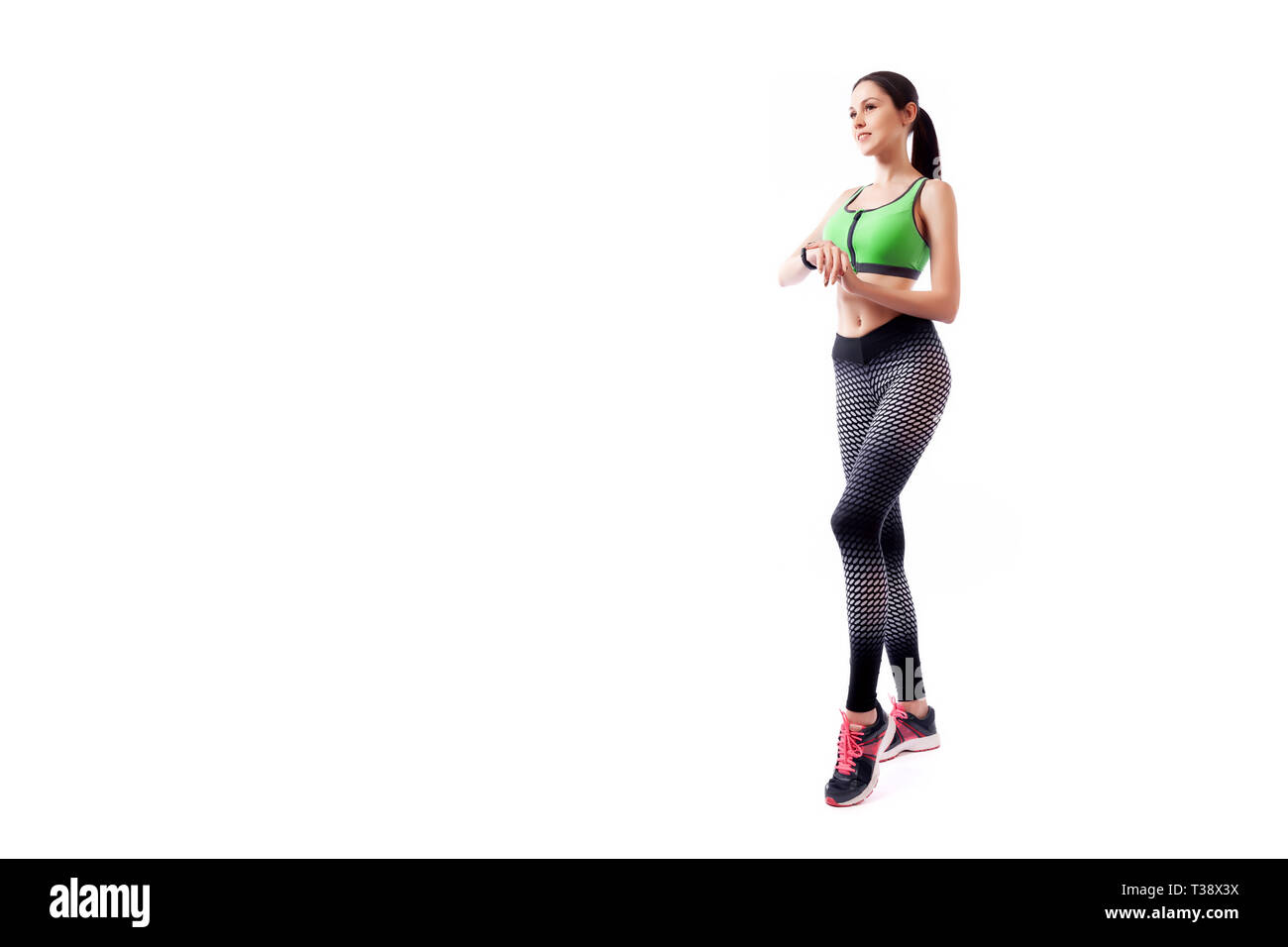 Young woman checking progress on smart watch on a white isolated ...
