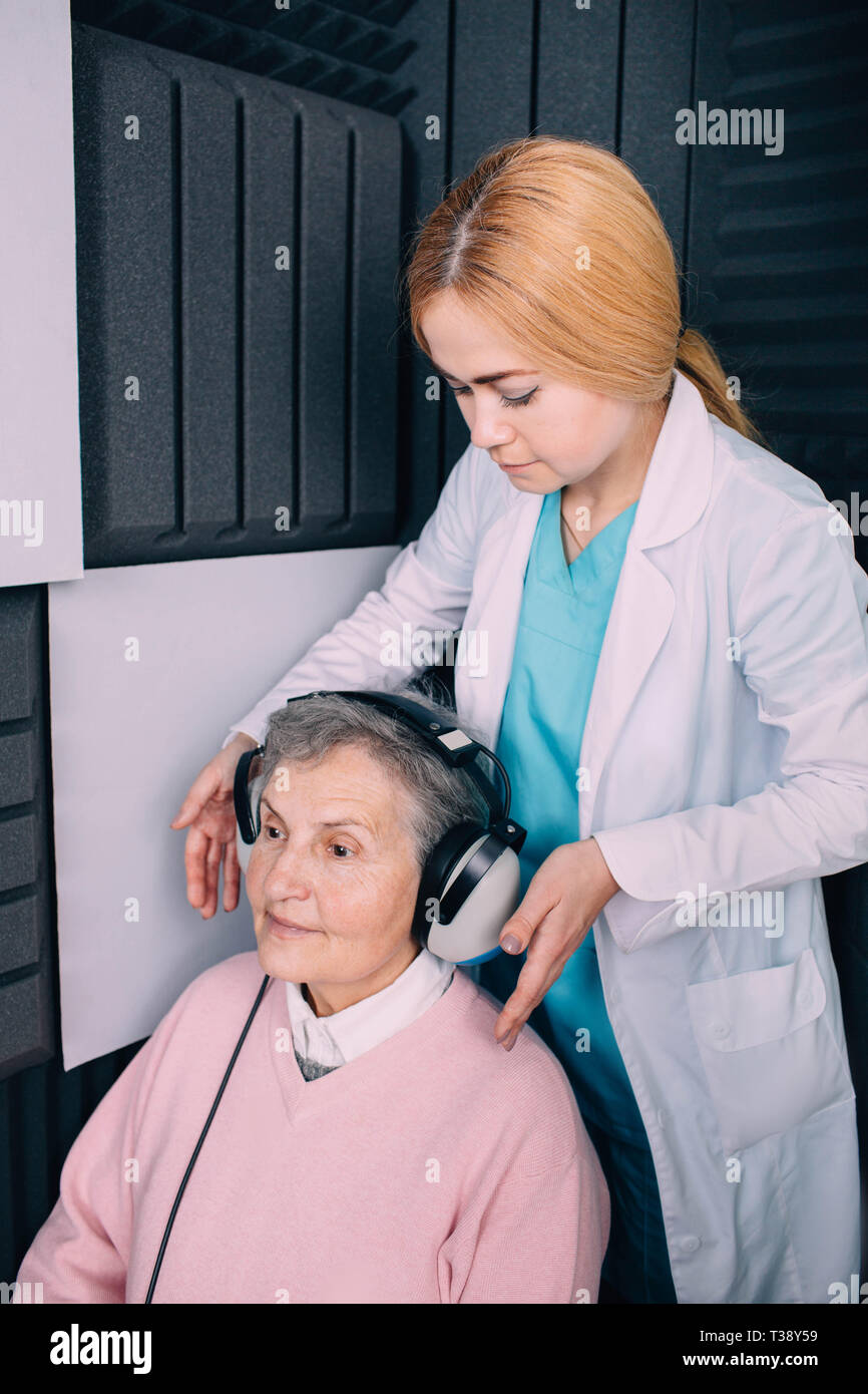 Audiologist placing a headset on senior patient for audiometric test ...