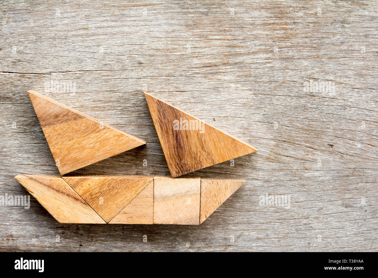 Tangram puzzle in sailing boat on wooden background (Concept for start ...