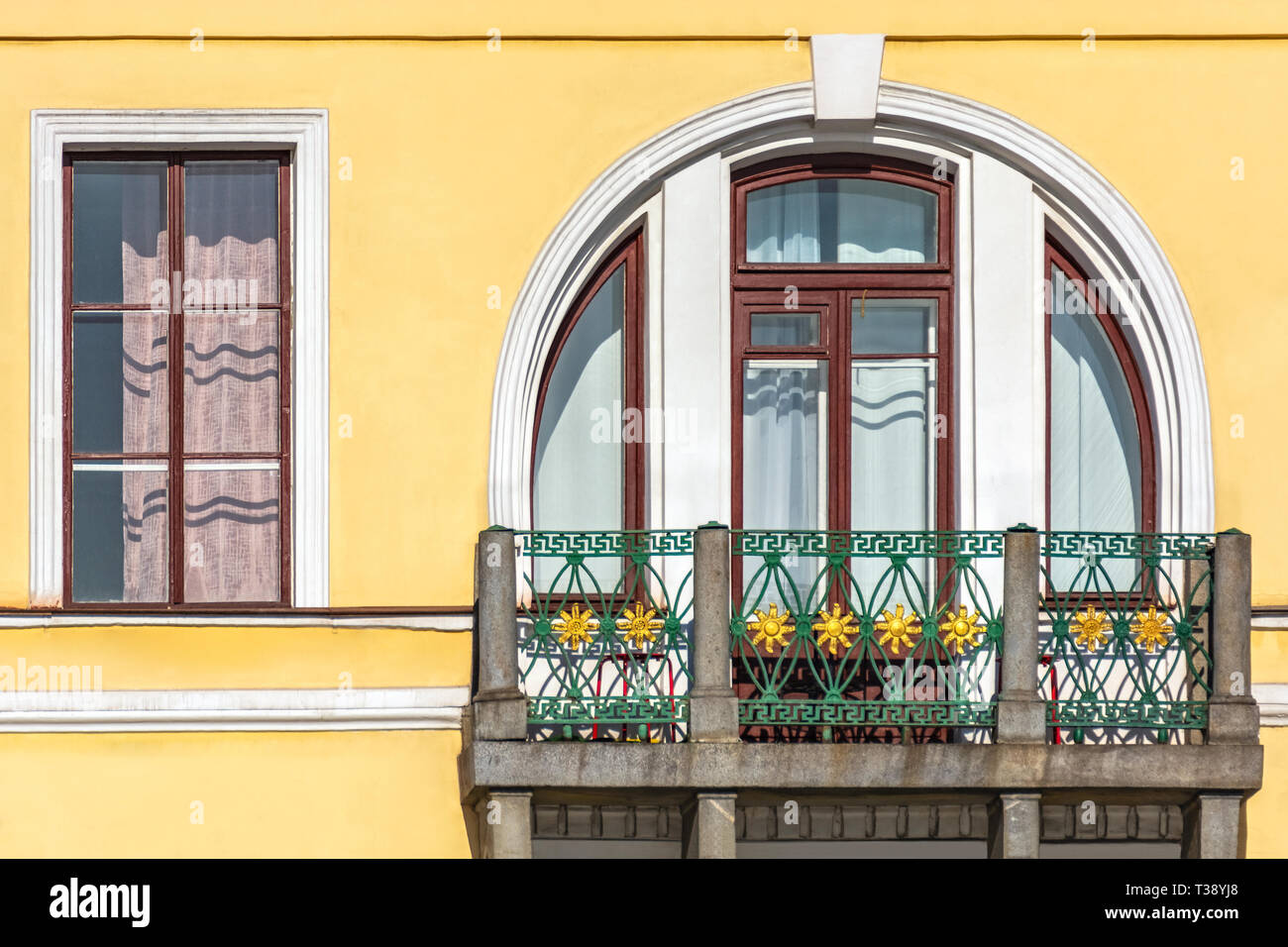 Semicircular window with a balcony against the background of the yellow ...