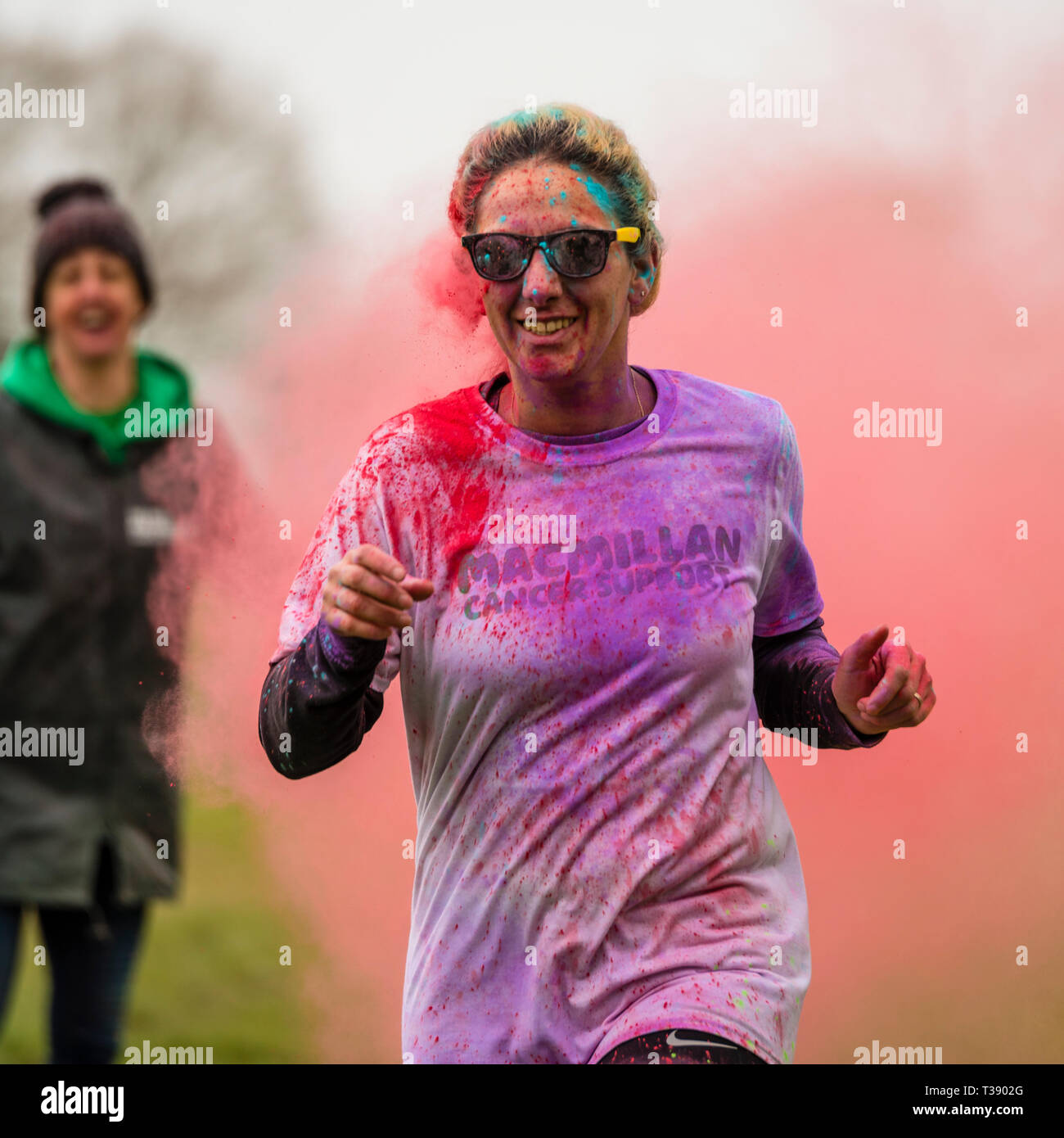 Female runner laughing and being covered in paint on Macmillan cancer ...