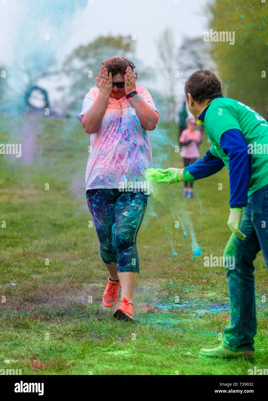 Adult female walker with hands over her face being covered in paint on ...