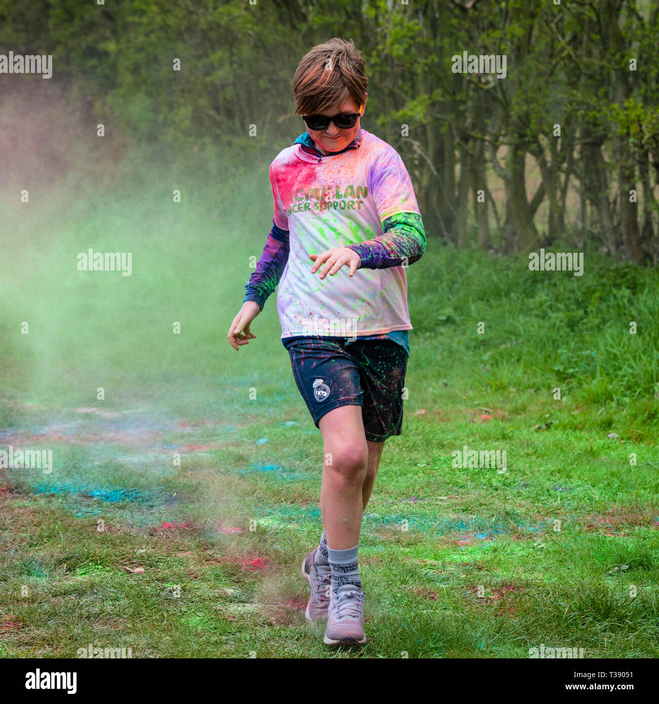 Young boy running hard and covered in paint on Macmillan cancer charity ...