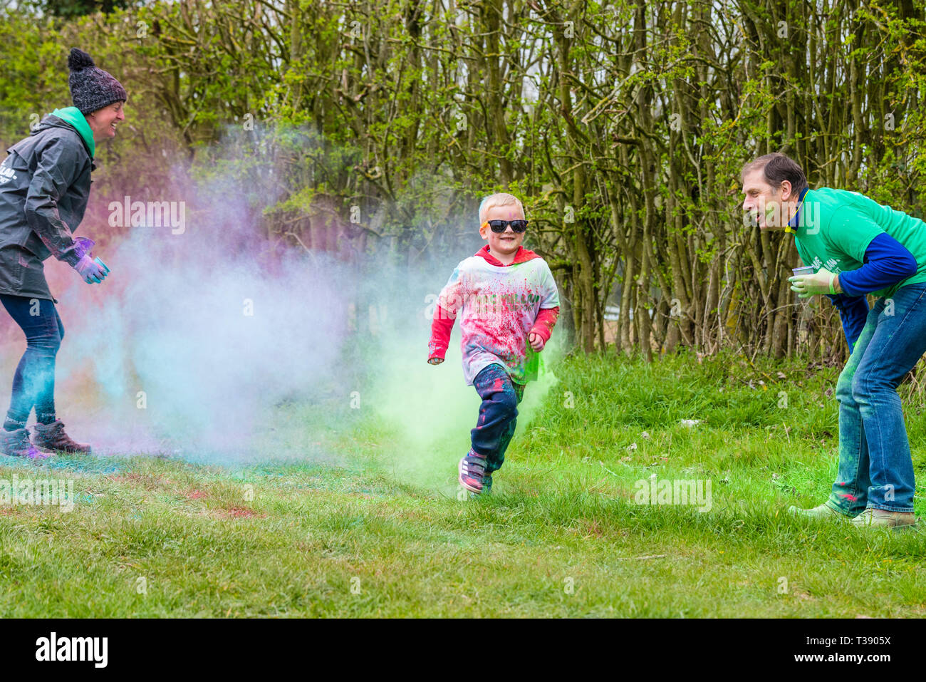 Small boy running hard and being covered in paint on Macmillan cancer ...