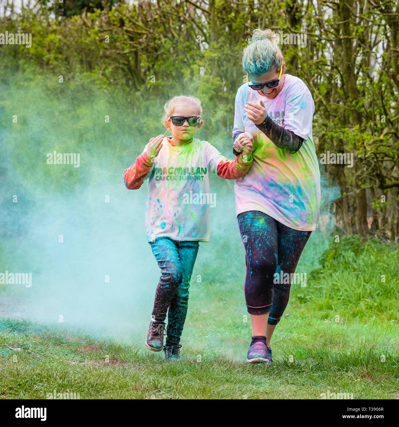 Mother and daughter runners holding hands and being covered in paint on ...