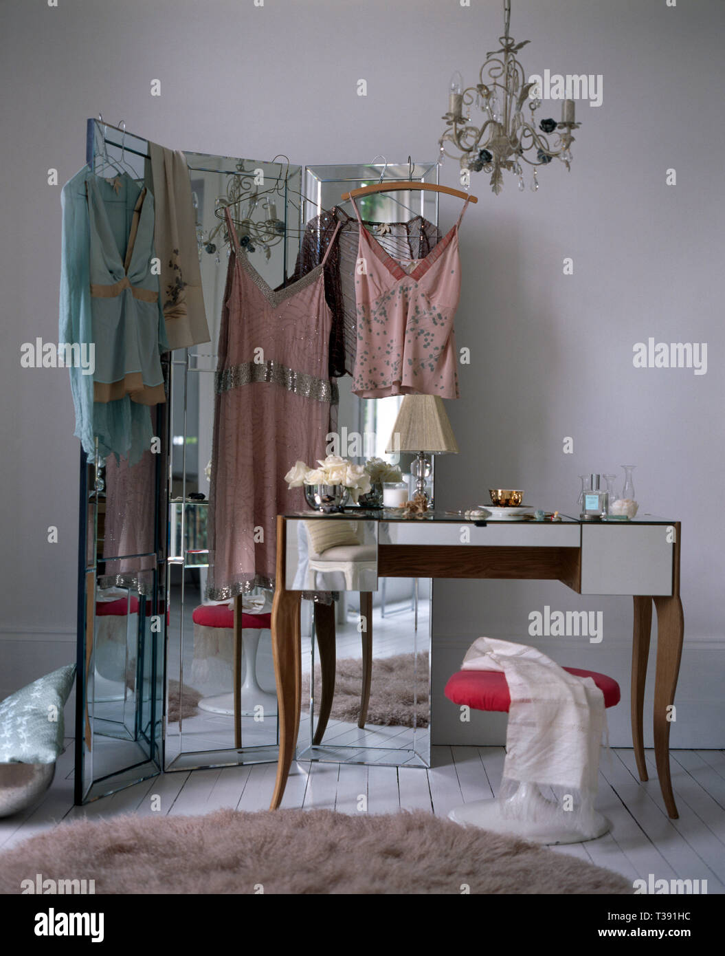 Clothing on mirrored screen beside mirrored dressing table Stock Photo ...