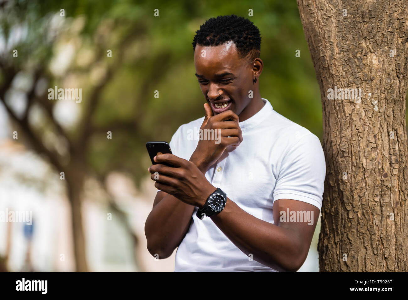 Outdoor portrait of a Young black African American men texting on ...