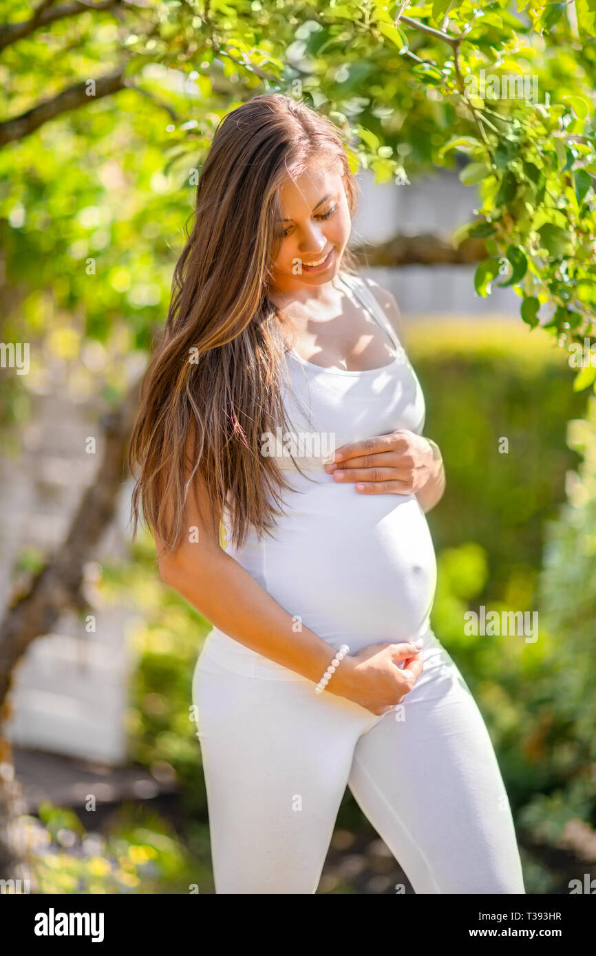 Woman looking down at pregnant belly hi-res stock photography and ...