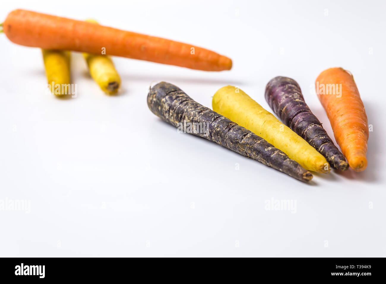 colourful organic carrots on white background Stock Photo - Alamy