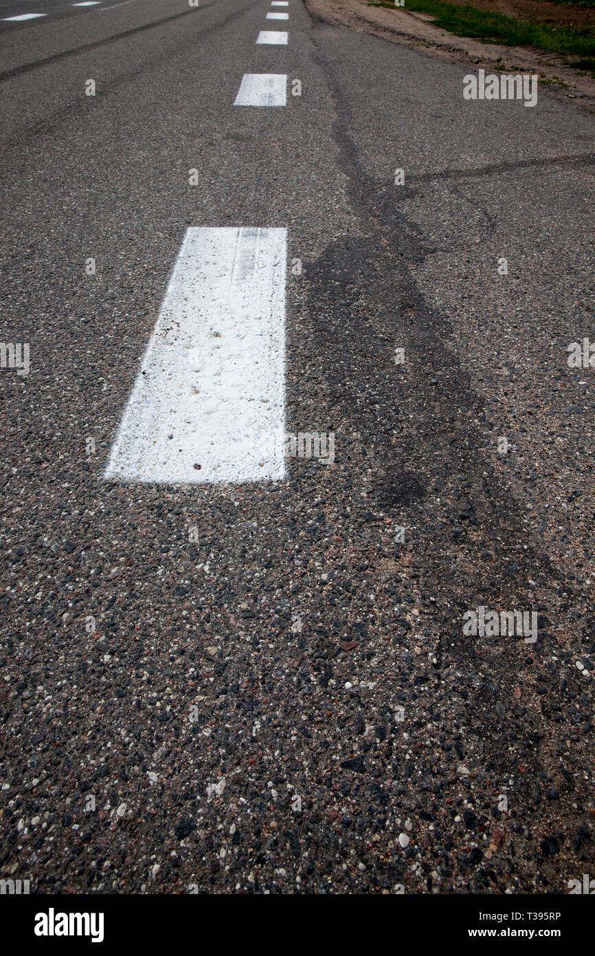 Intermittent white road markings on a black asphalt road Stock Photo ...