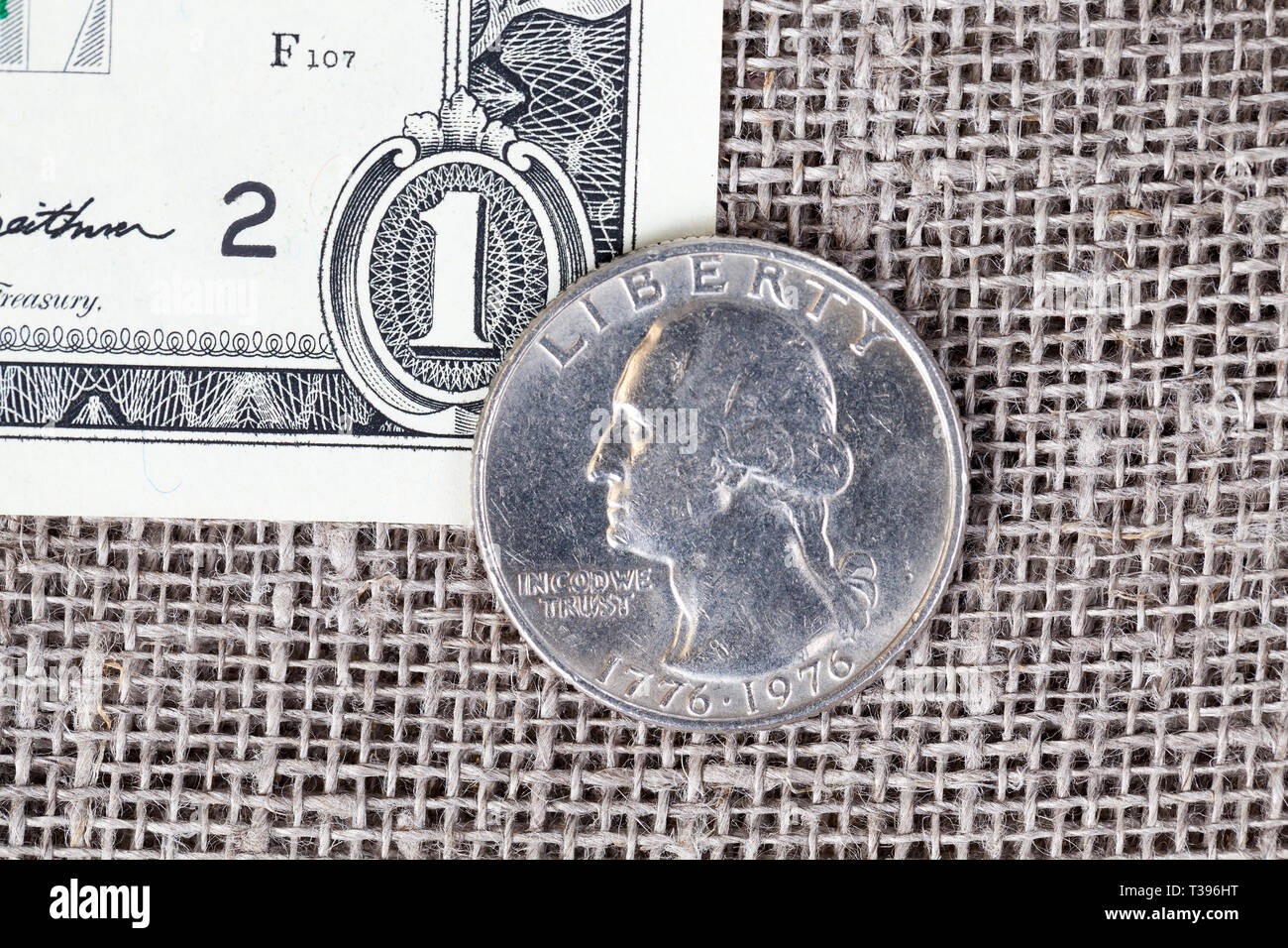 American paper banknotes and metal coins lying on a rough linen ...
