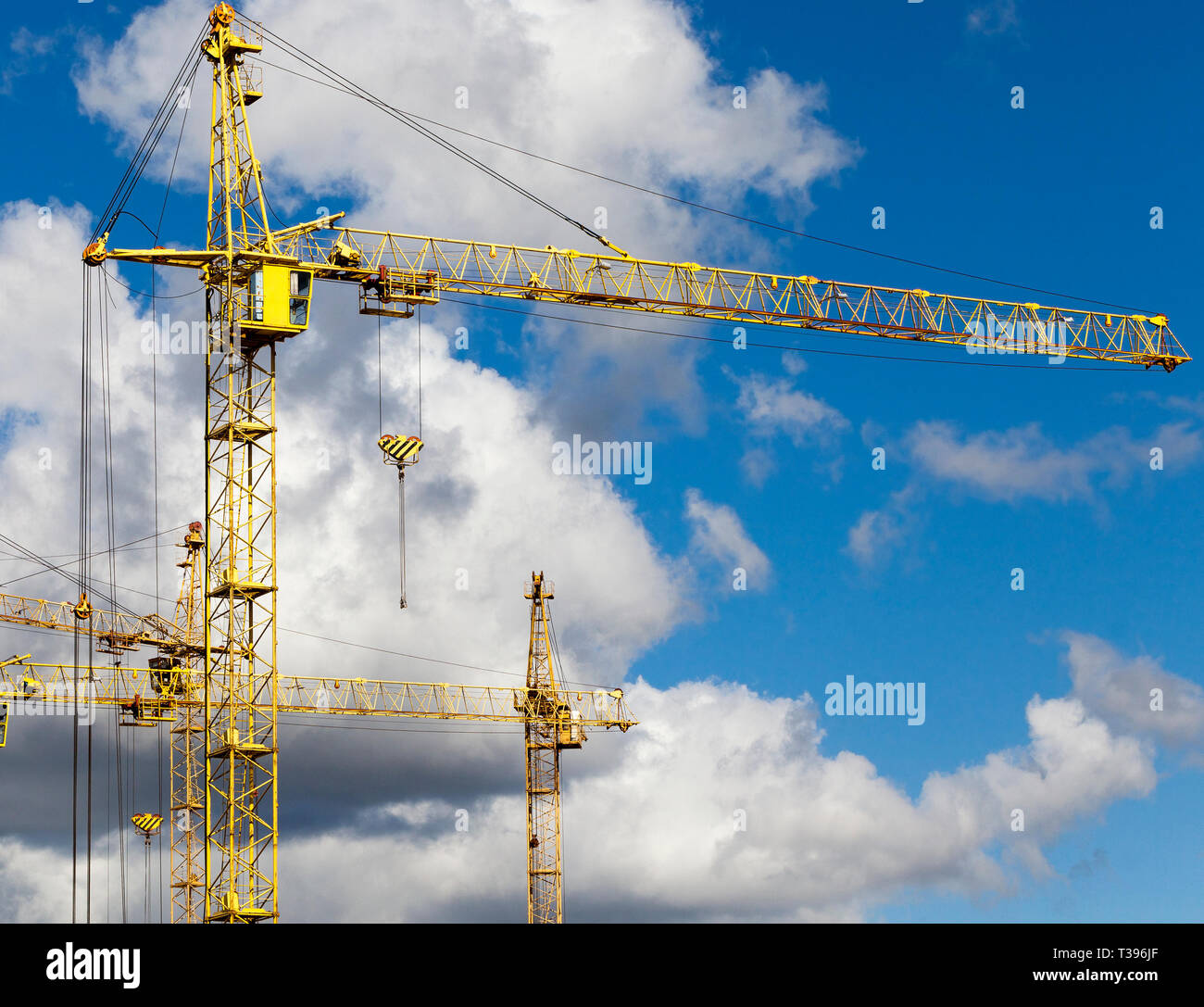 High construction cranes of yellow color on a construction site in a ...