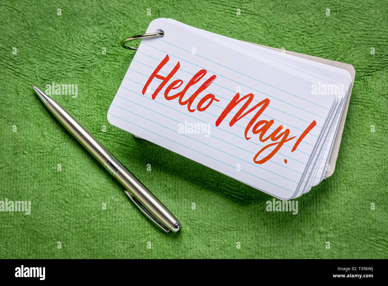 Hello May - handwriting on an index card with a pen against green ...