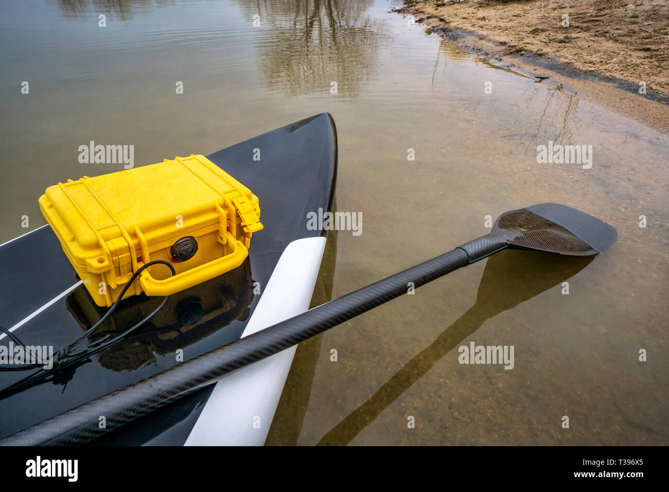 stand up paddleboard with a paddle and waterproof case Stock Photo - Alamy