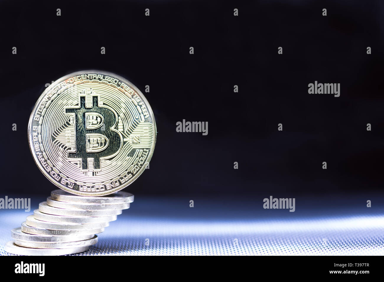 Front view of single golden bit coin with money stack on silver ...